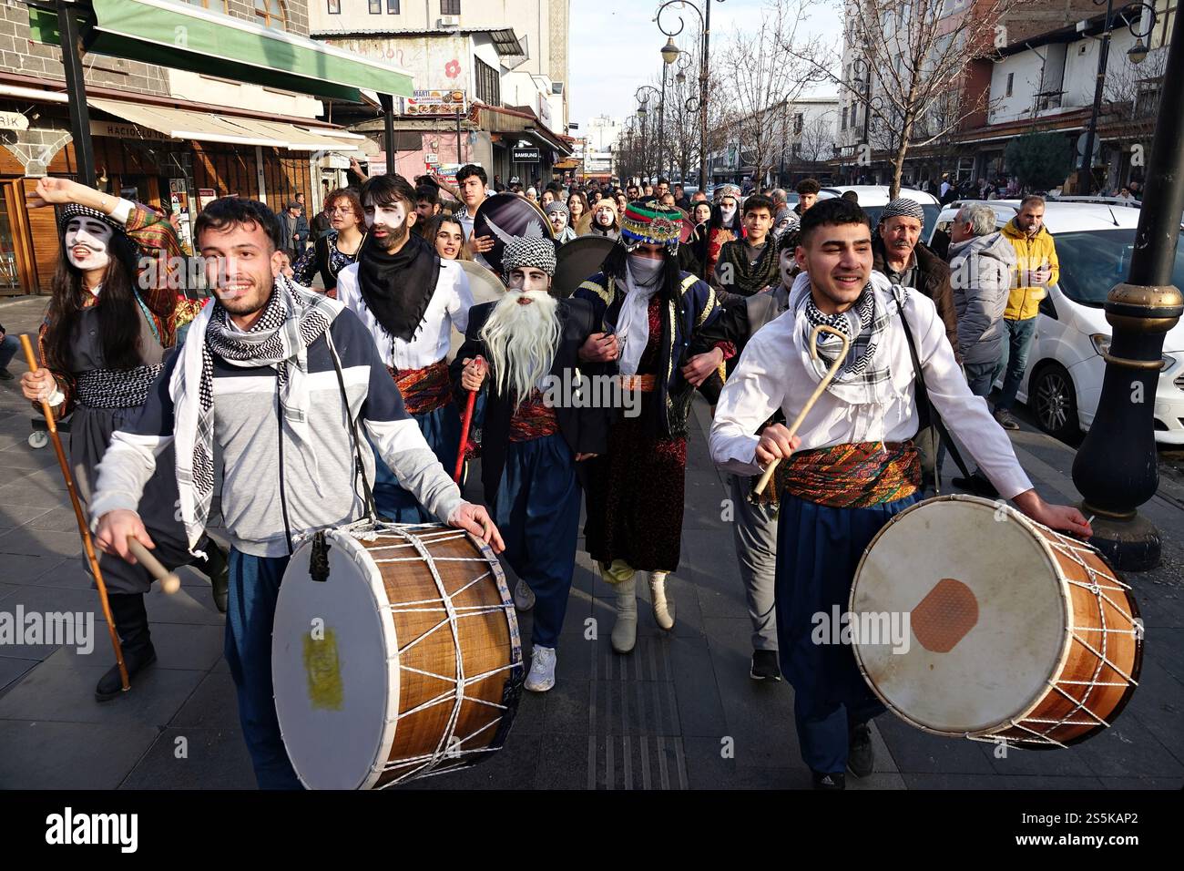 Artists from the Dicle Cultural Association are seen playing drums and ...