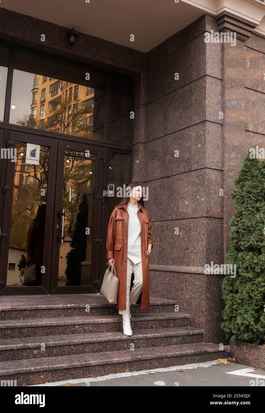 elegant woman over 40 exiting building with laptop bag Stock Photo - Alamy