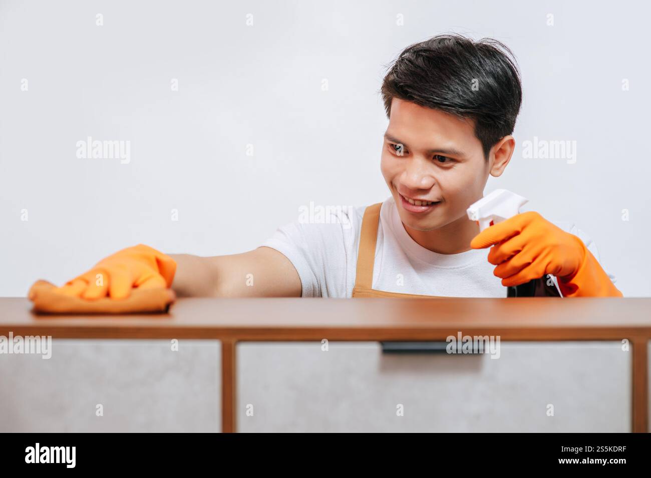 Asian young handsome man was spray disinfectant bottle and using cloth ...