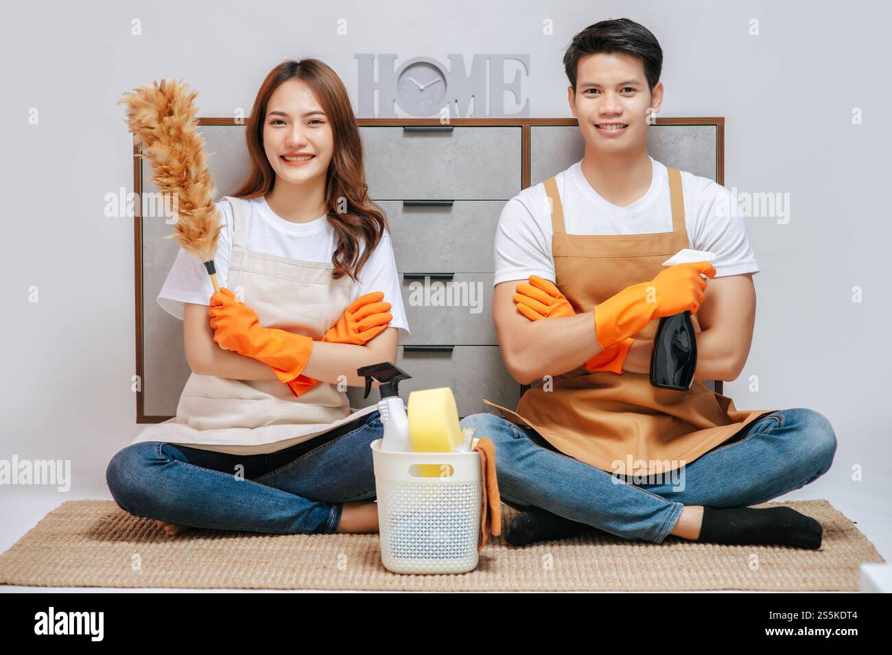 Portrait happy smiling young couple with equipment for cleaning house ...