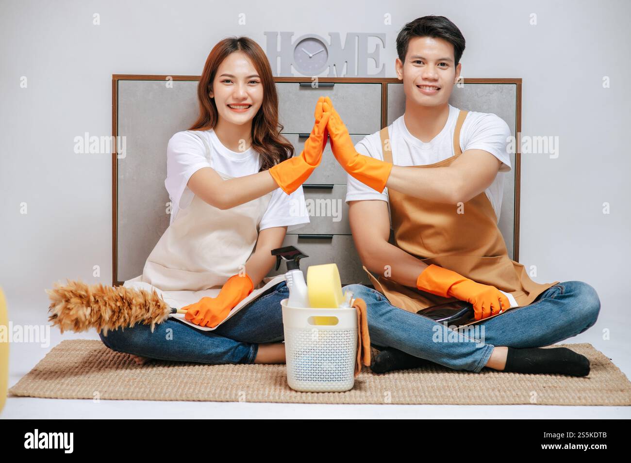 Portrait happy smiling young couple with equipment for cleaning house ...