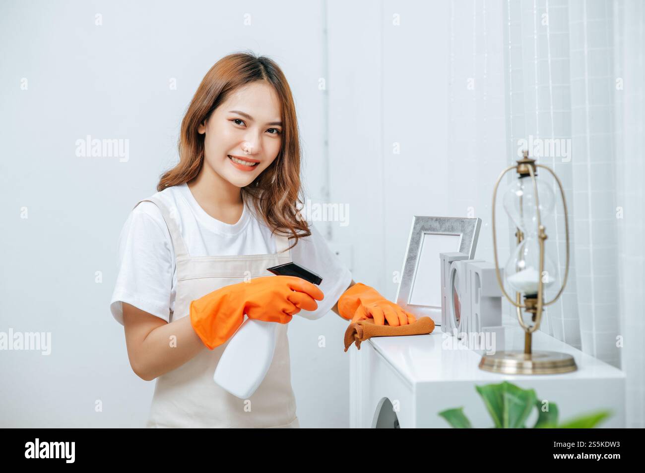 Portrait Young housekeeper woman wearing apron and rubber gloves use ...