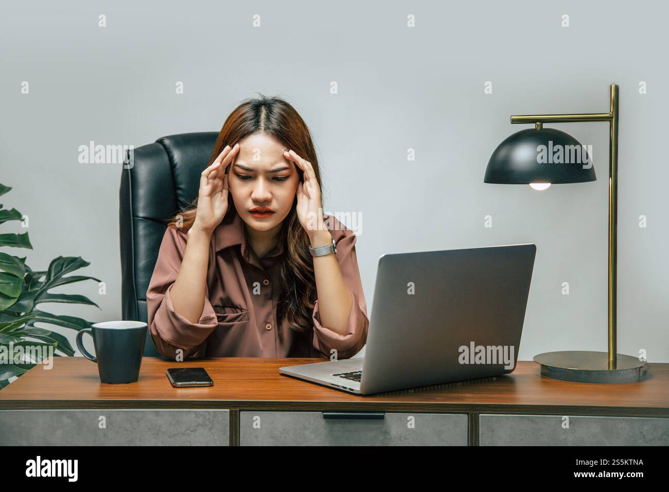 Stressed young working woman sitting at her desk, she works from home ...