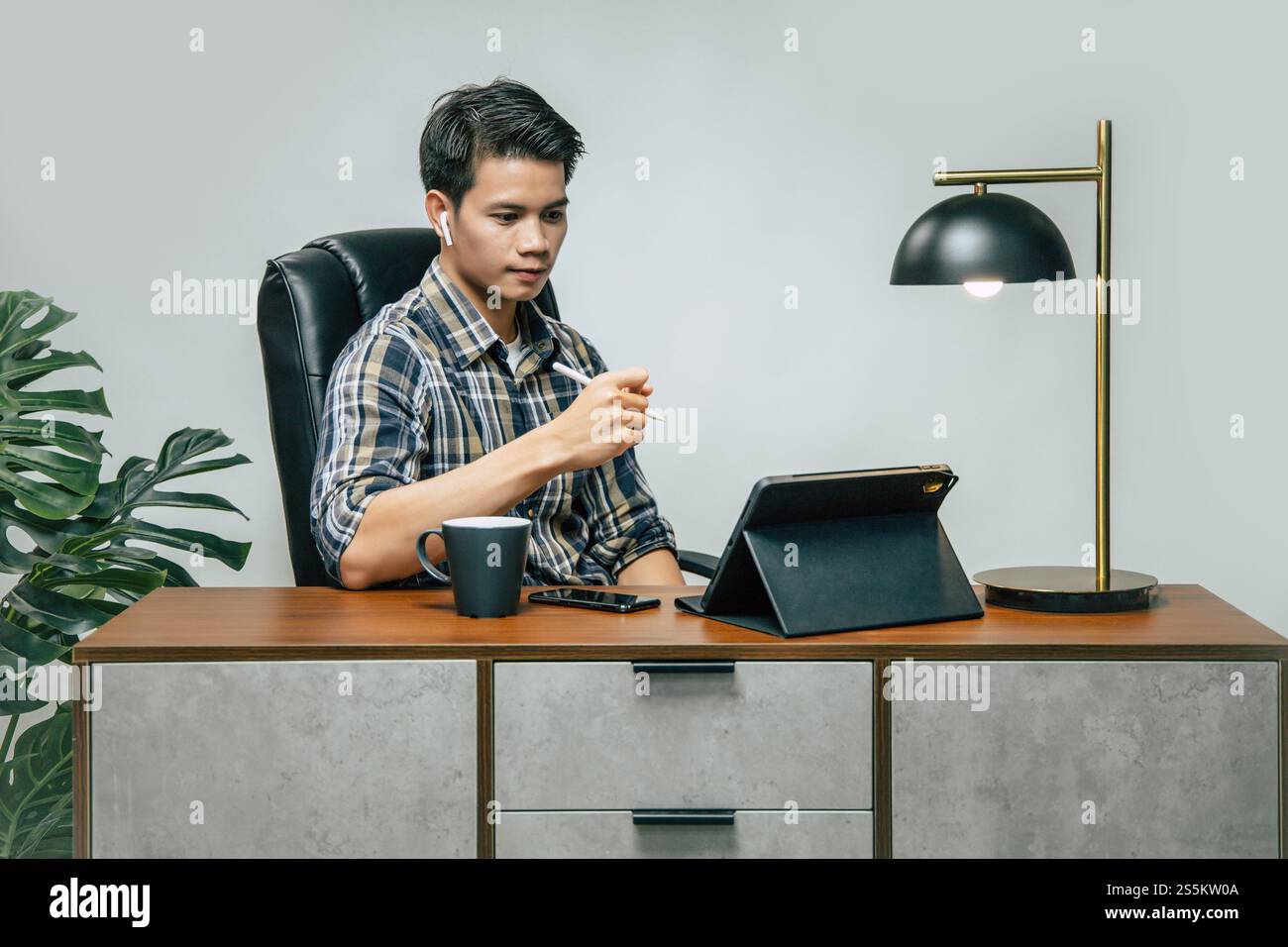 Happily Young handsome man with new normal, Stay at home and works from home on digital tablet ...