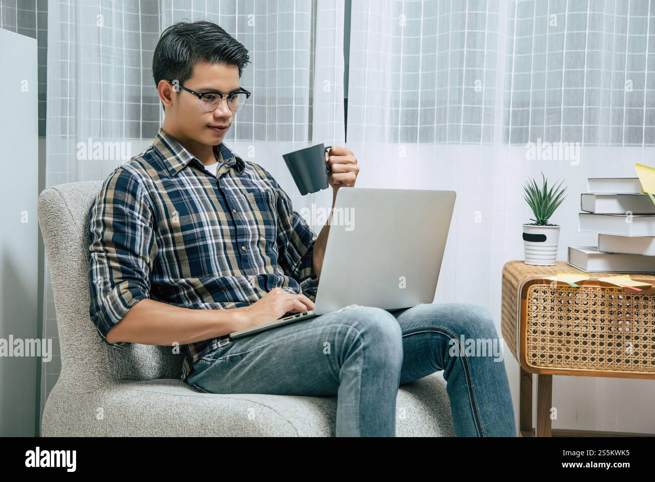 Portrait of smiling handsome man in glasses relaxing with coffee, using ...
