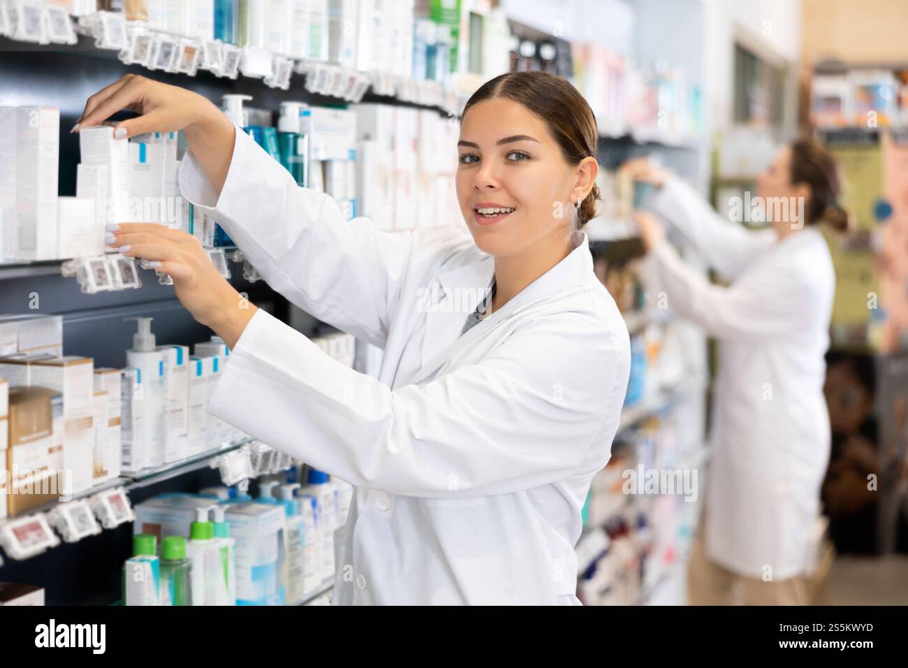 Female pharmacist puts goods on the shelves - healing cosmetics and ...