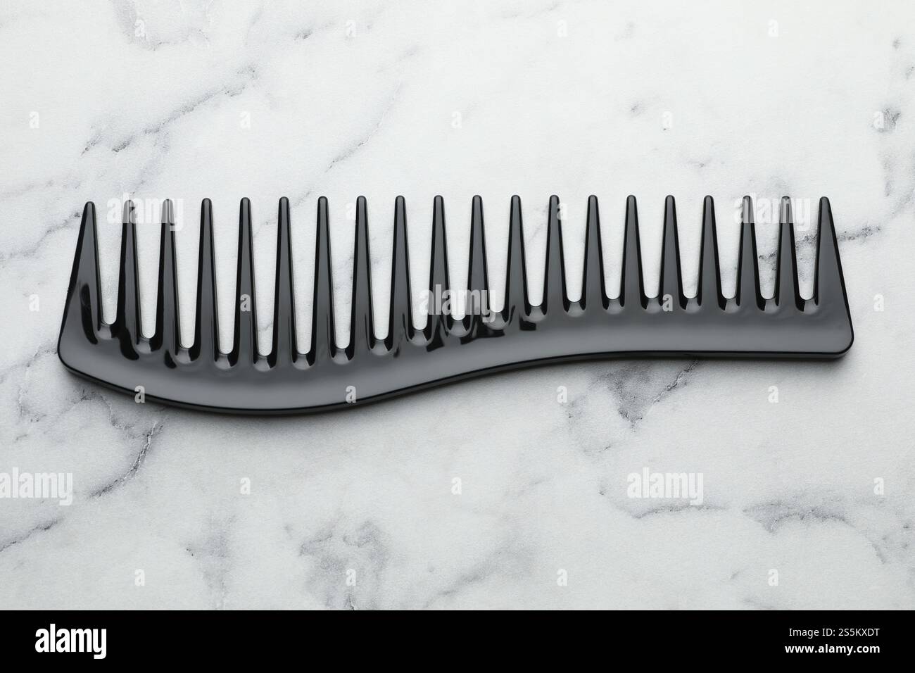One black plastic comb on white marble table, top view Stock Photo - Alamy