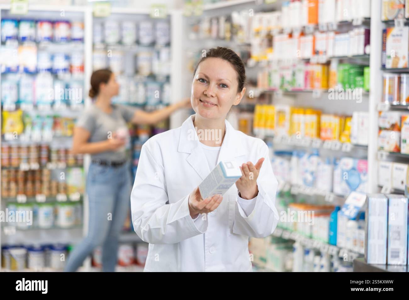 In pharmacy, apothecary holds package with cream for sensitive skin and ...