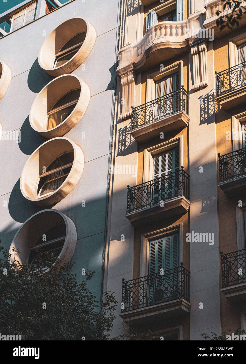Afternoon shadows cast on a Barcelona urban building. Circular windows ...