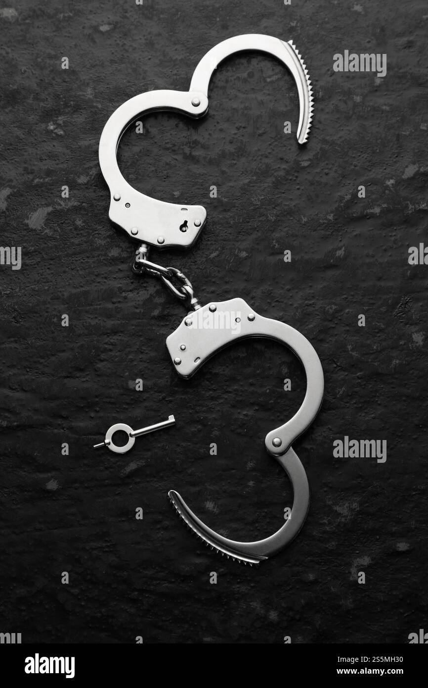 Metal chain handcuffs and key on black table, top view Stock Photo - Alamy