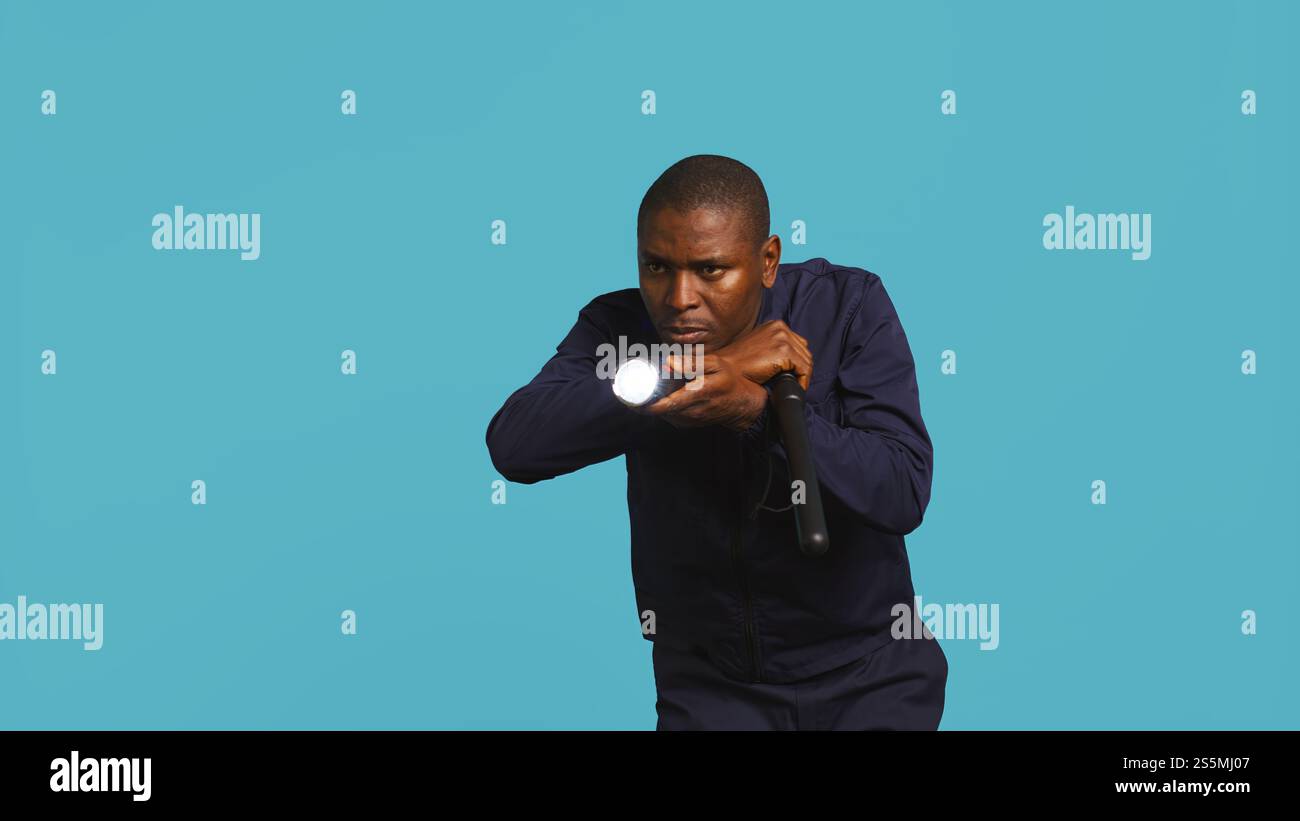 Portrait of security guard overseeing premises, turning on flashlight ...