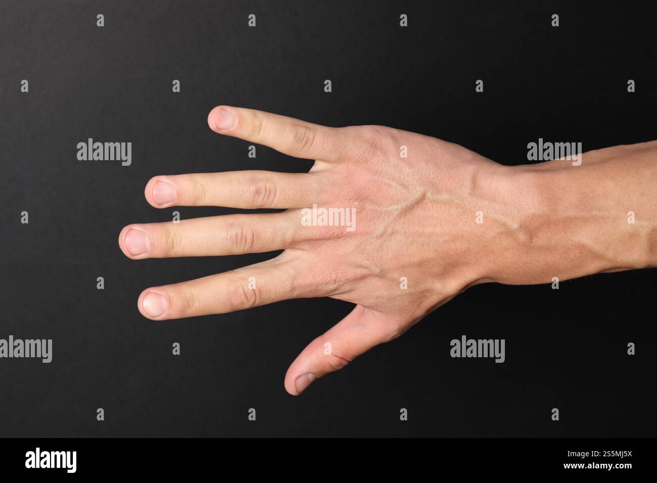 Man with bulging veins on his arm against black background, closeup ...