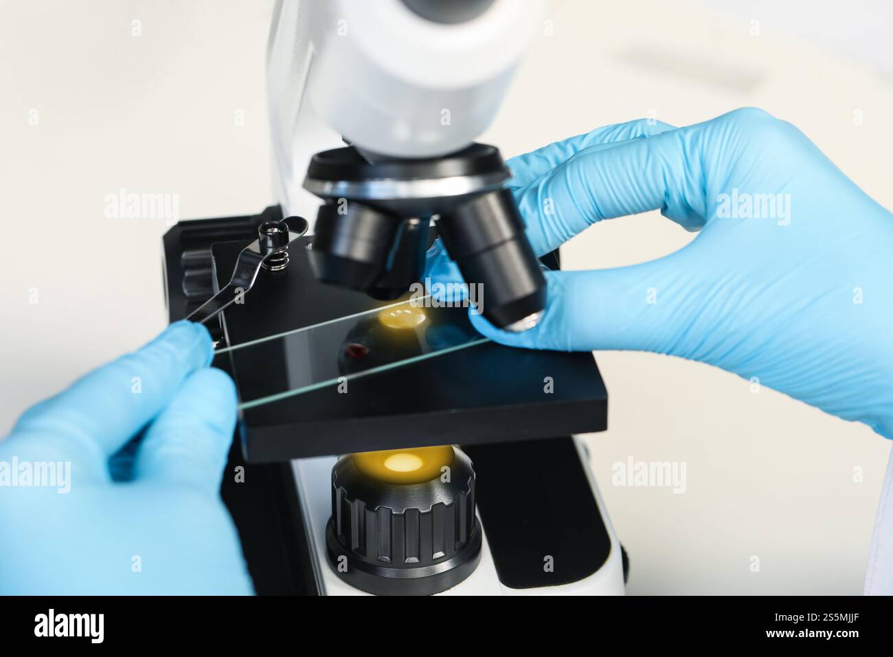 Scientist examining sample on slide under microscope, closeup Stock ...