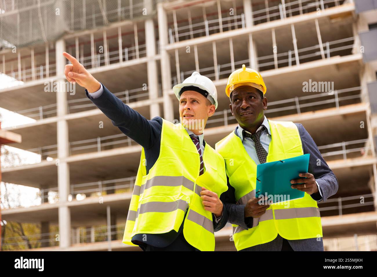 Two architect, civil engineer or building contractor colleagues on ...