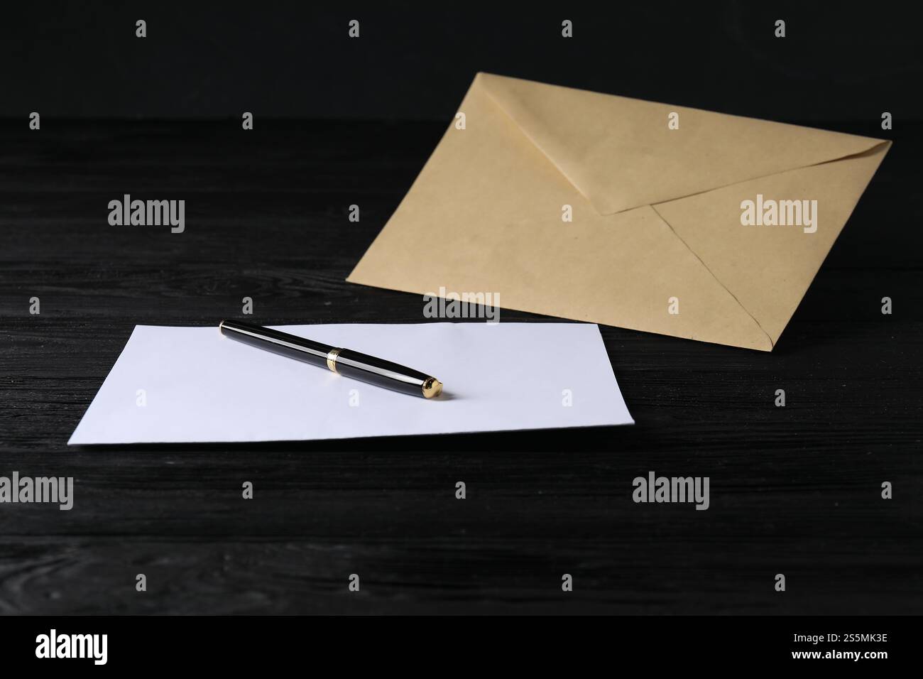 Kraft paper envelope with letter and pen on black wooden table. Mockup ...