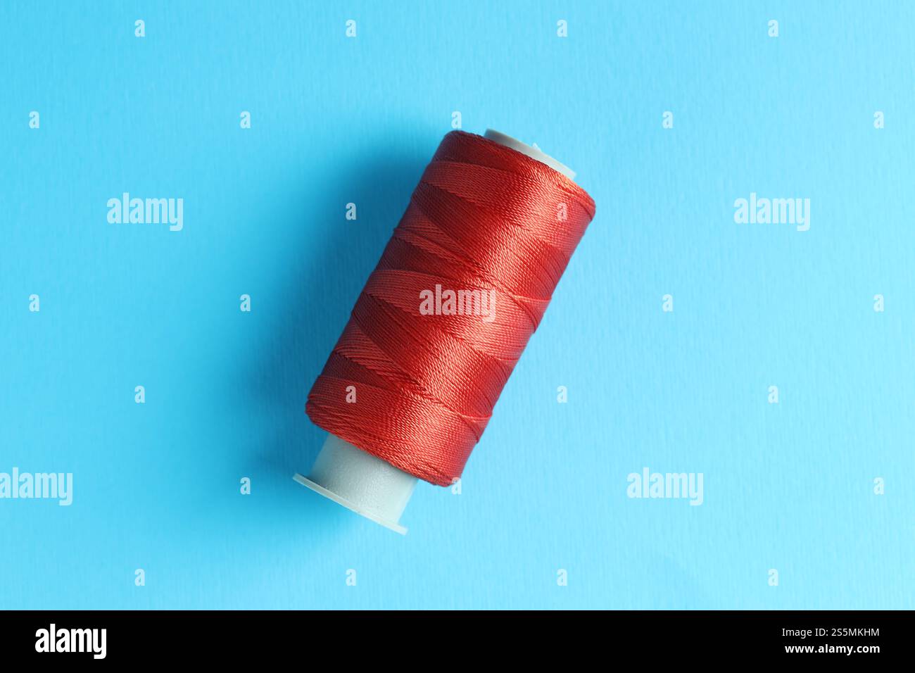 Spool of red sewing thread on light blue background, top view Stock ...