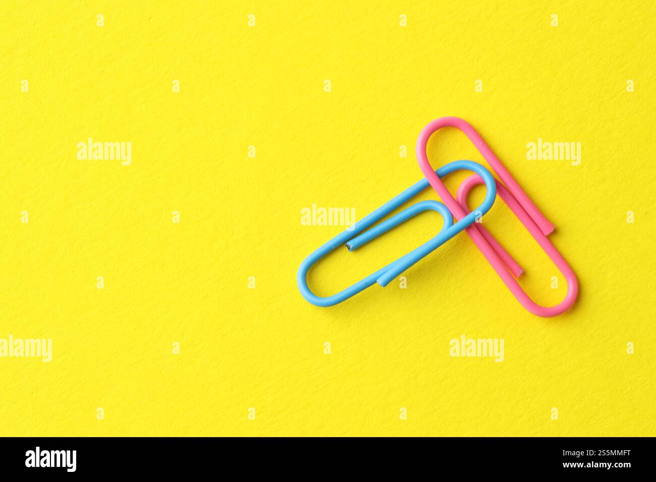 Two paper clips on yellow background, top view. Space for text Stock ...