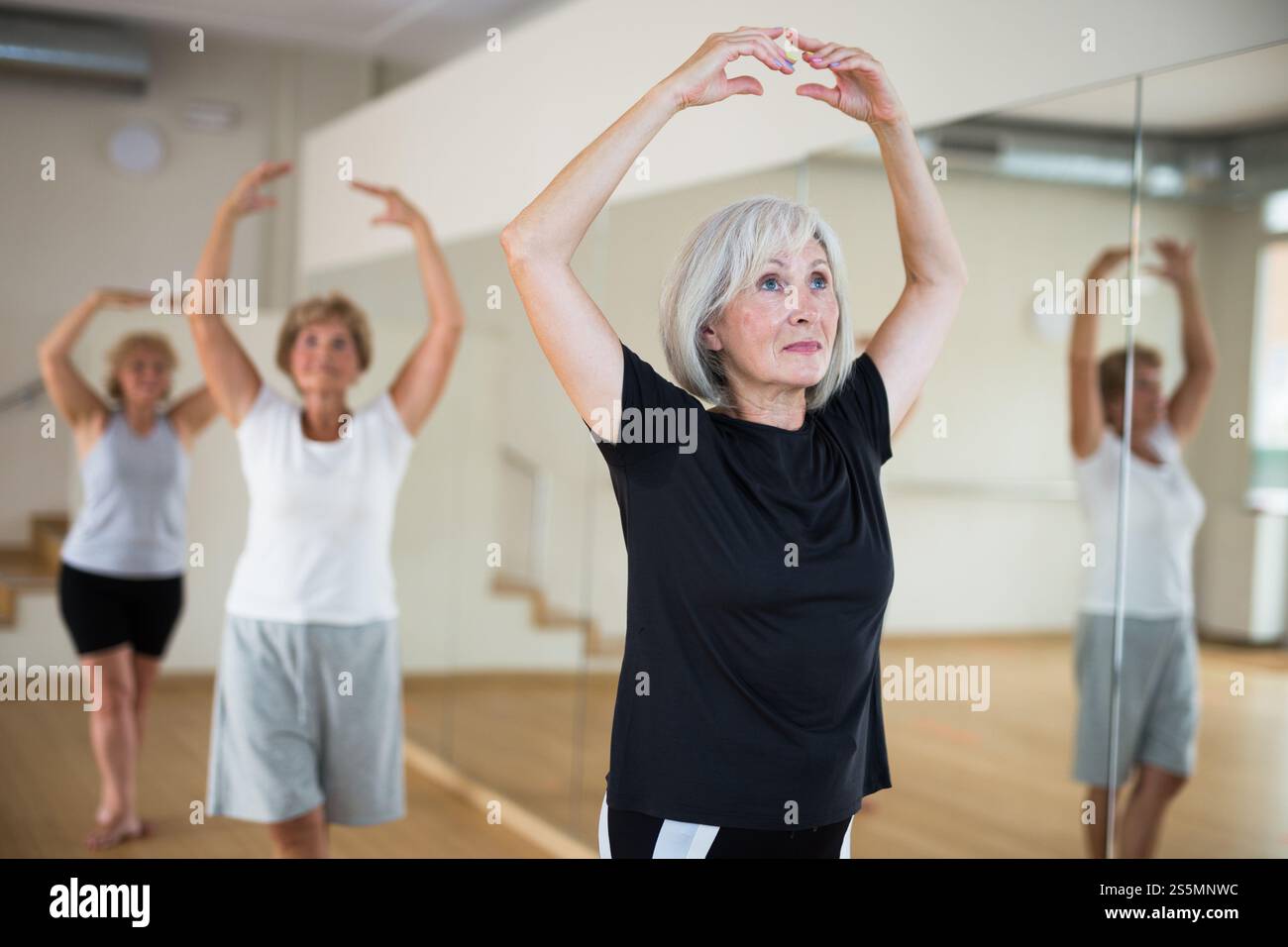 Mature woman practicing classic dance moves during group class Stock ...