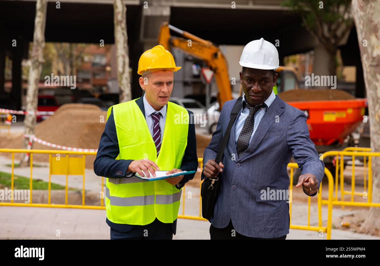 Foreman and engineer check correctness of the pipeline repair on street ...