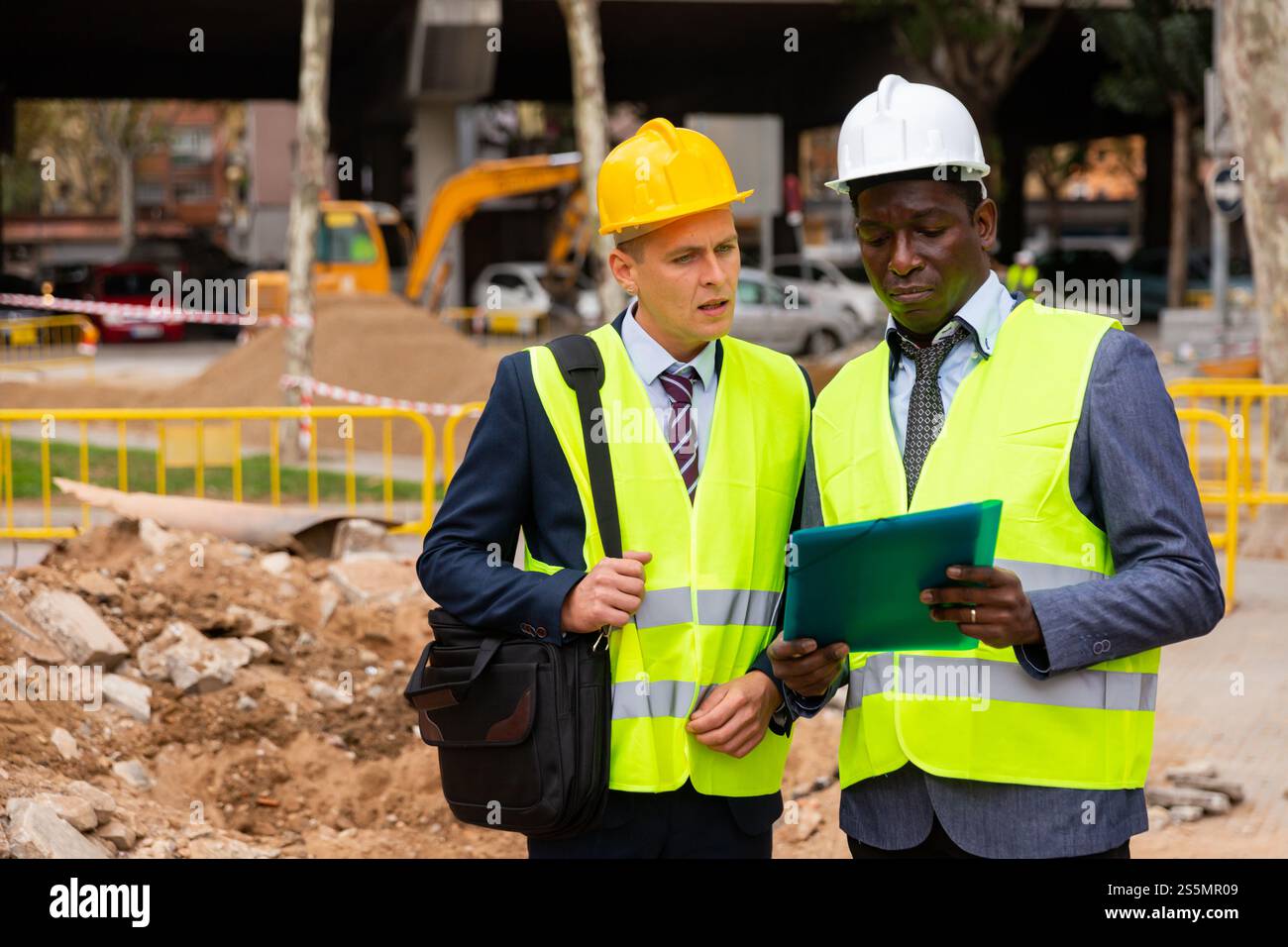 Two engineers talking about road repairing works documentation Stock ...