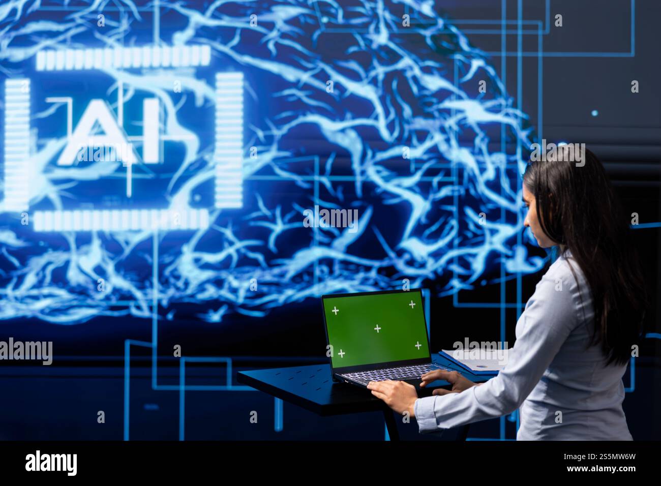 Startup employee looking over charts, using AI software on mockup laptop to take data driven ...