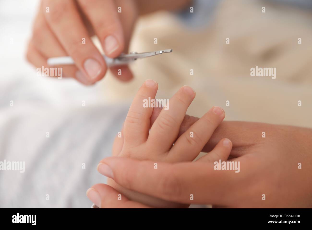 Mother cutting her cute little baby's nails on bed, closeup Stock Photo ...