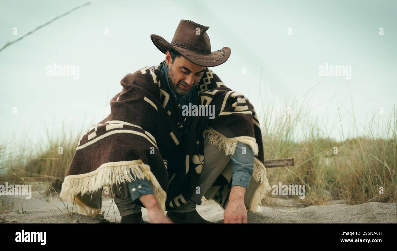 Man digs with his hands in the sand Stock Photo - Alamy