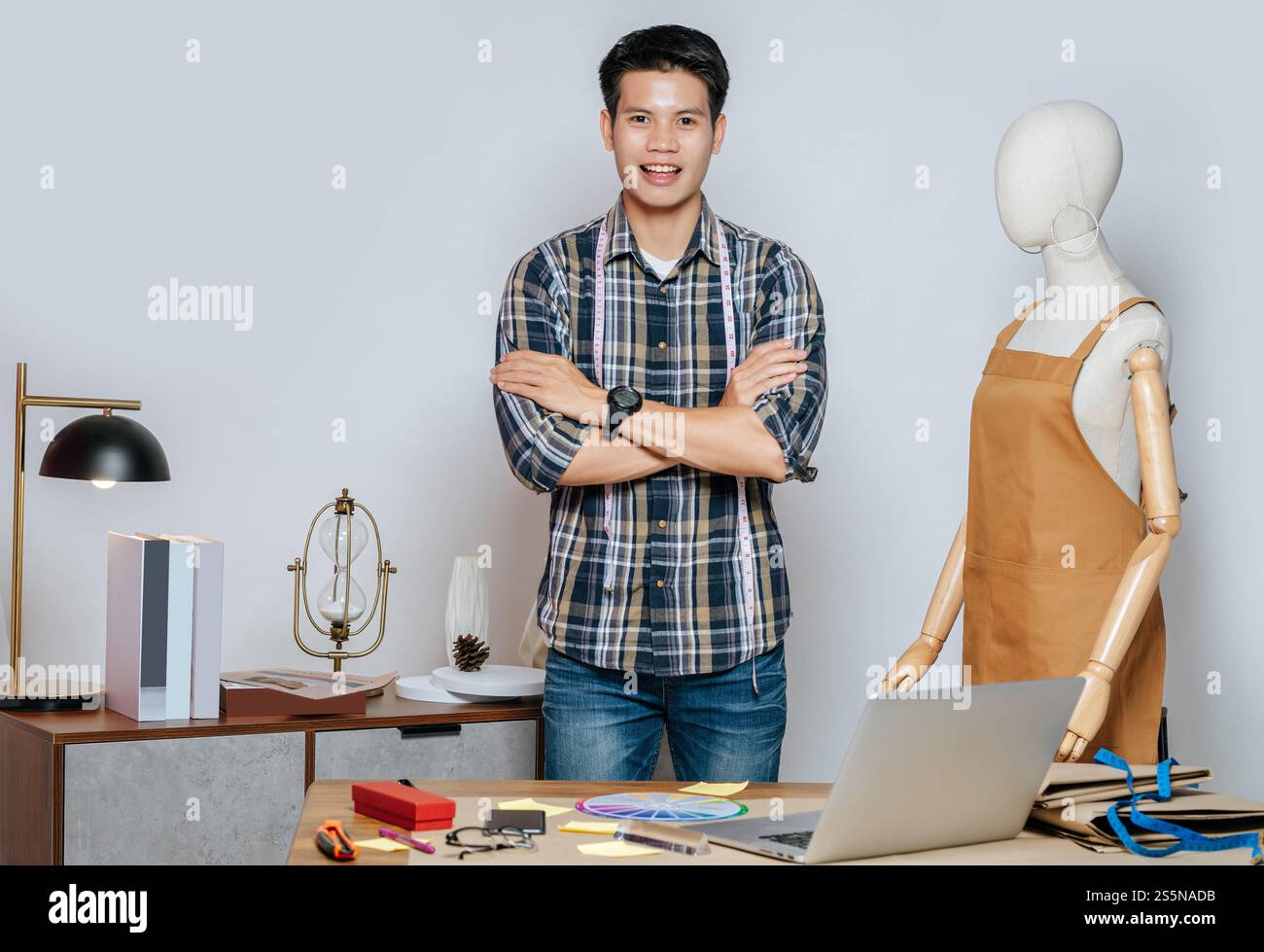 Portrait young Asian fashion designer or tailor working with laptop ...
