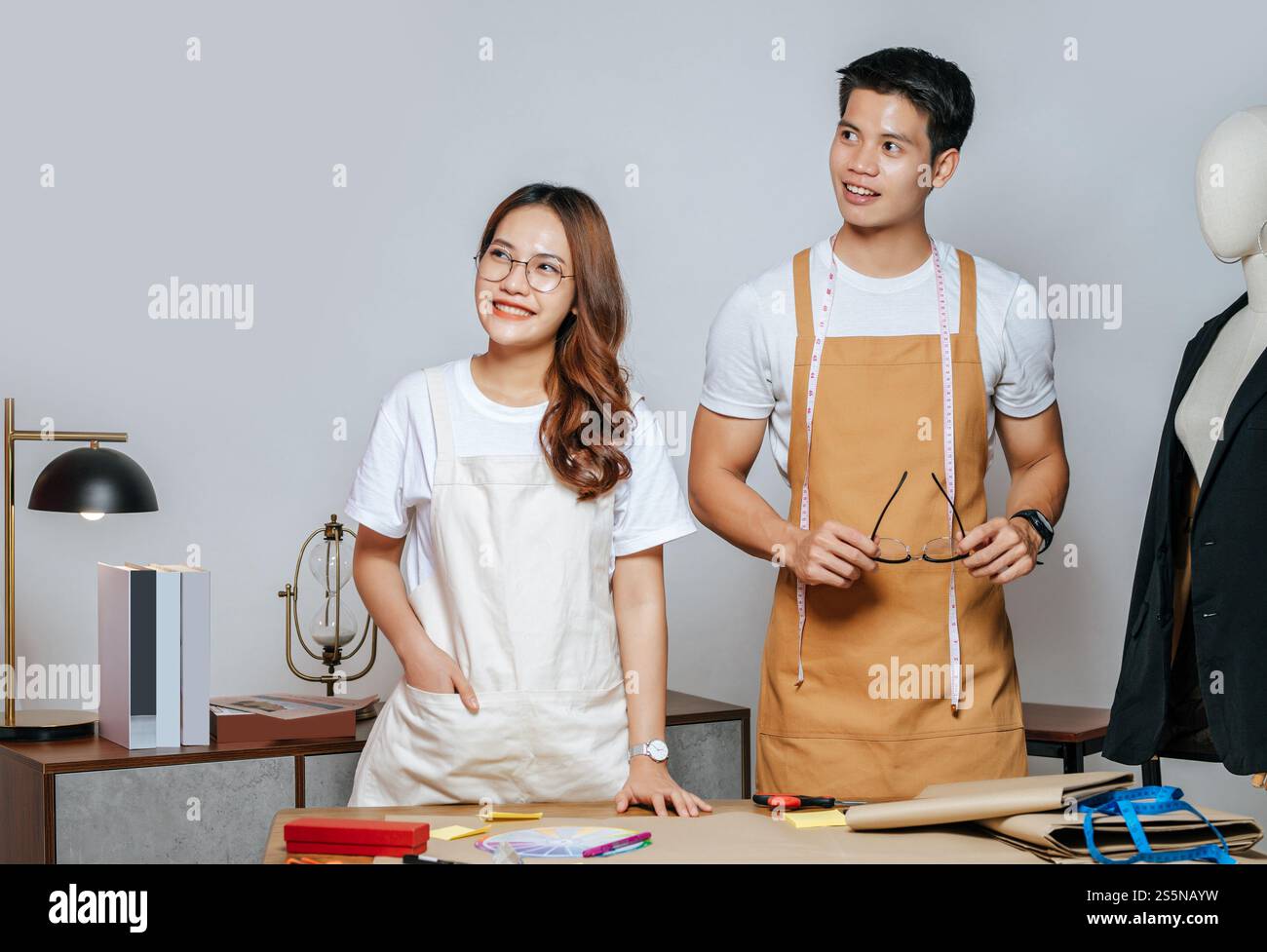 Portrait Young handsome man and pretty woman in glasses wearing apron ...