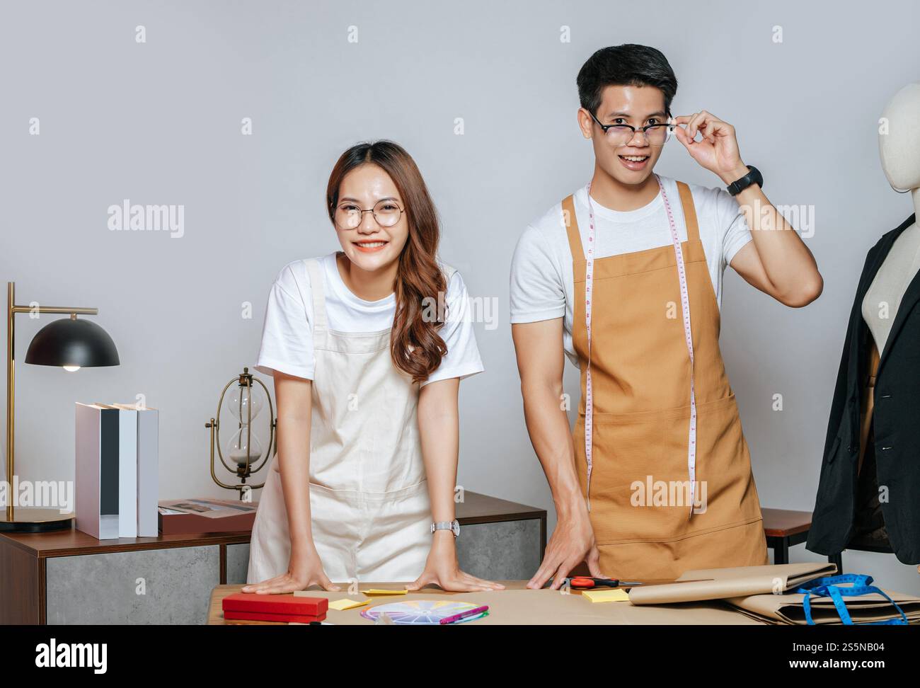 Portrait Young handsome man and pretty woman in glasses wearing apron ...