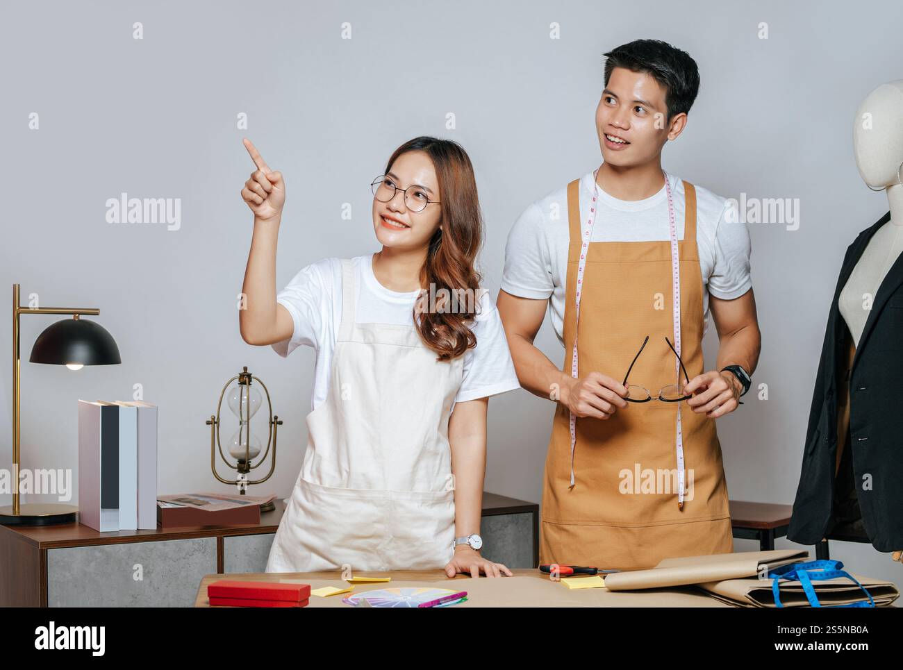 Portrait Young handsome man and pretty woman in glasses wearing apron ...