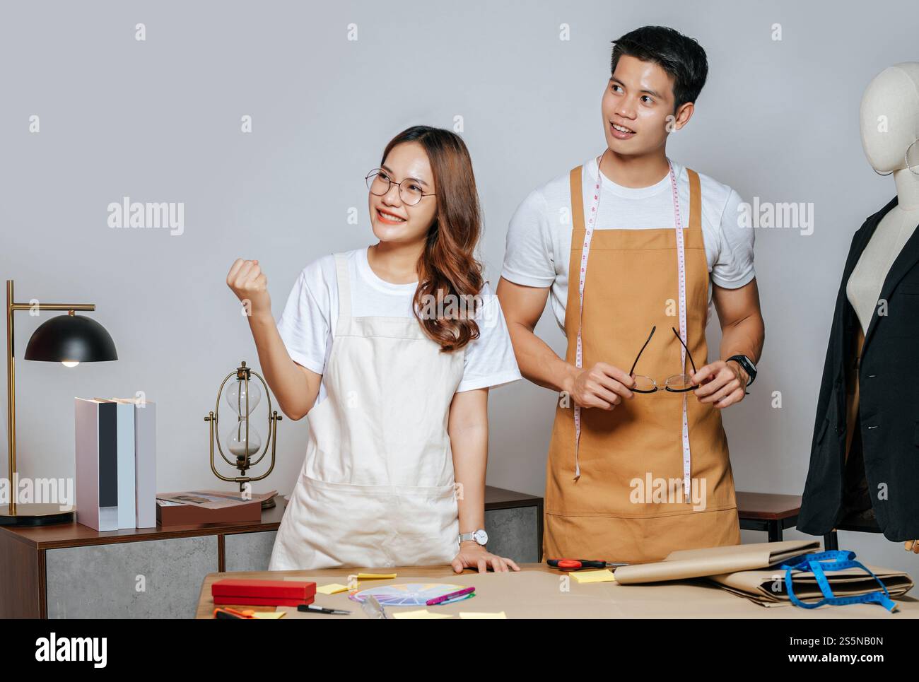 Portrait Young handsome man and pretty woman in glasses wearing apron ...