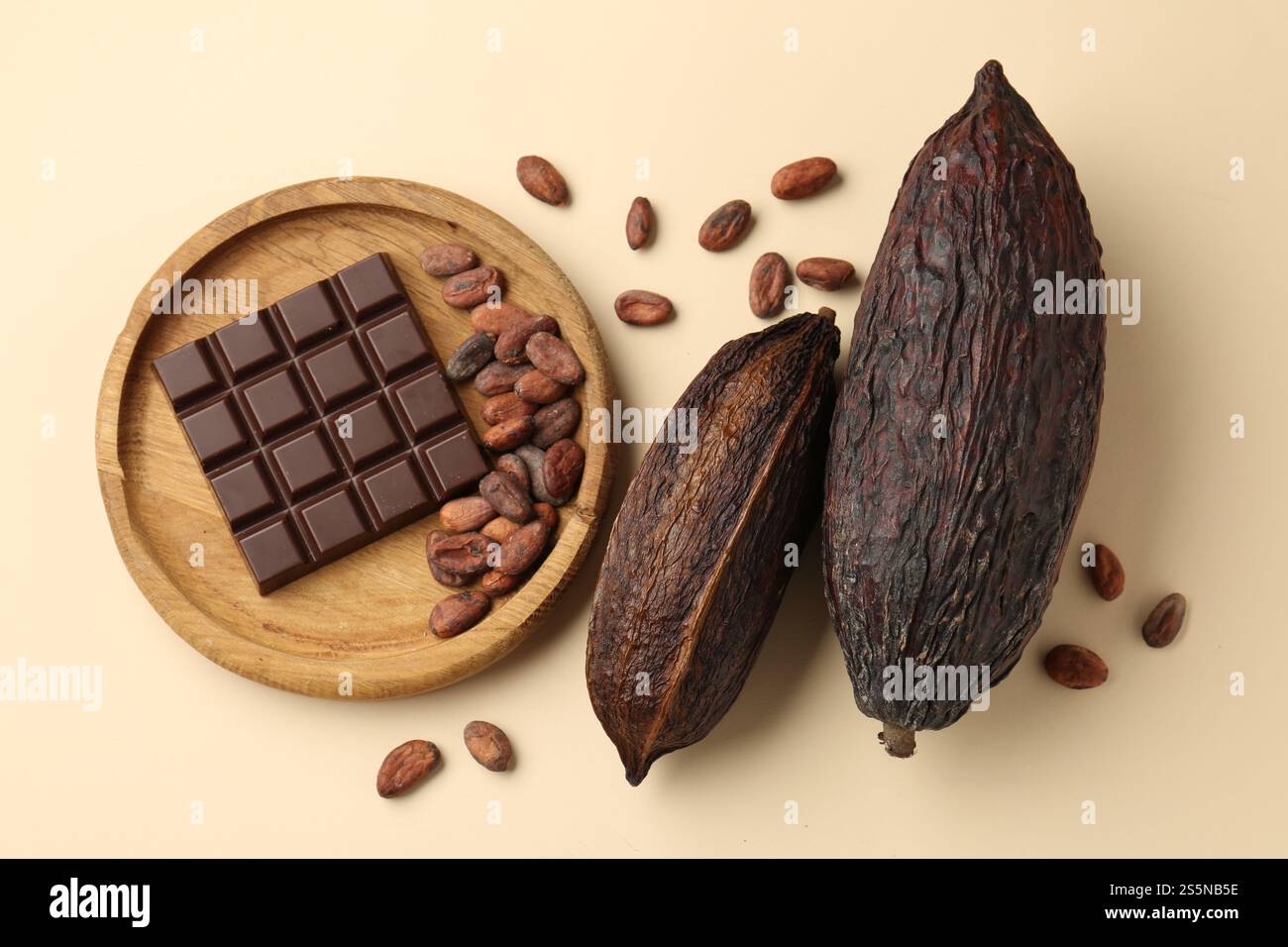 Cocoa pods, beans and chocolate bar on beige background, flat lay Stock ...