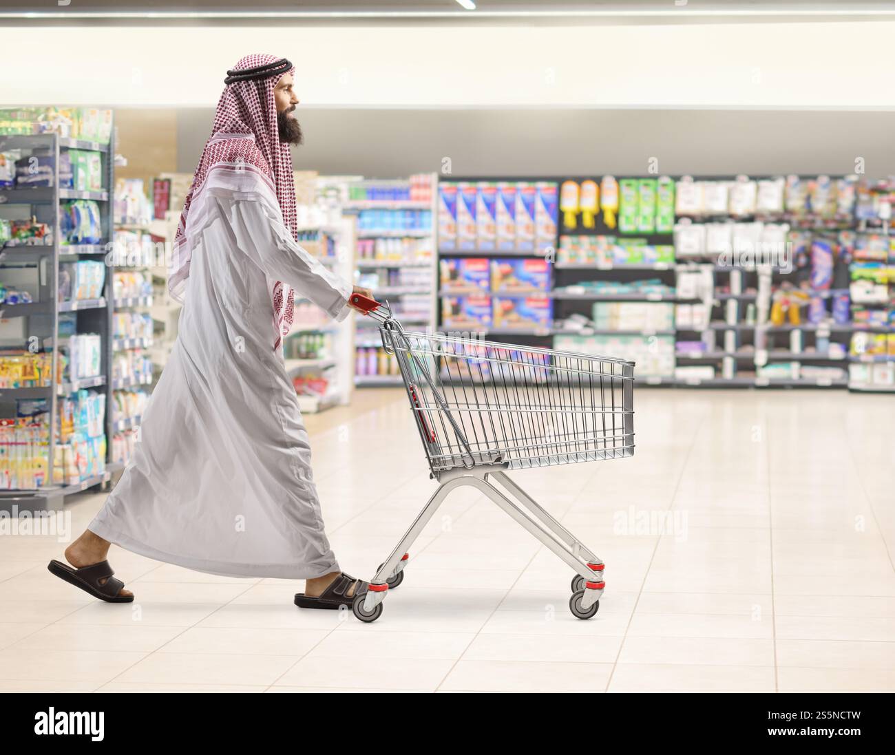 Full length profile shot of a saudi arab man walking and pushing a ...
