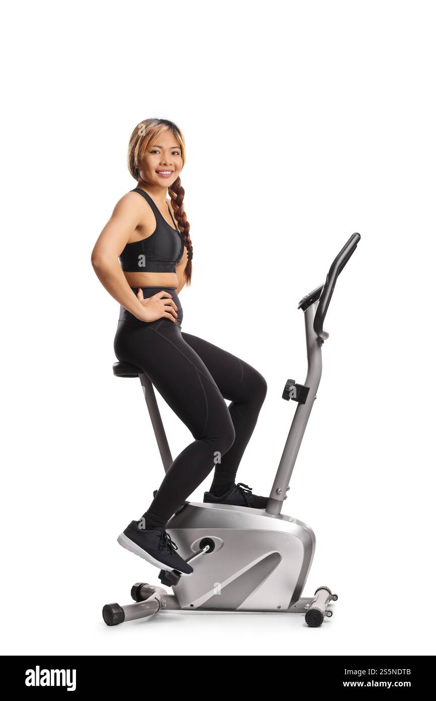 Young asian female sitting on a workout indoor bike isolated on white ...