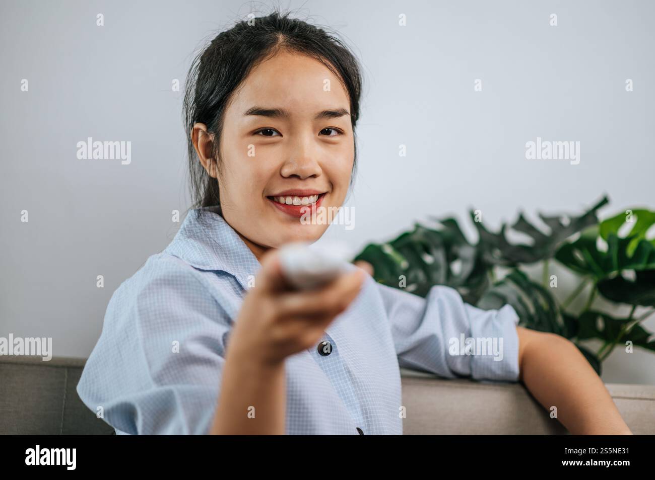 Selective focus face of Smiley Young woman holding and use remote ...