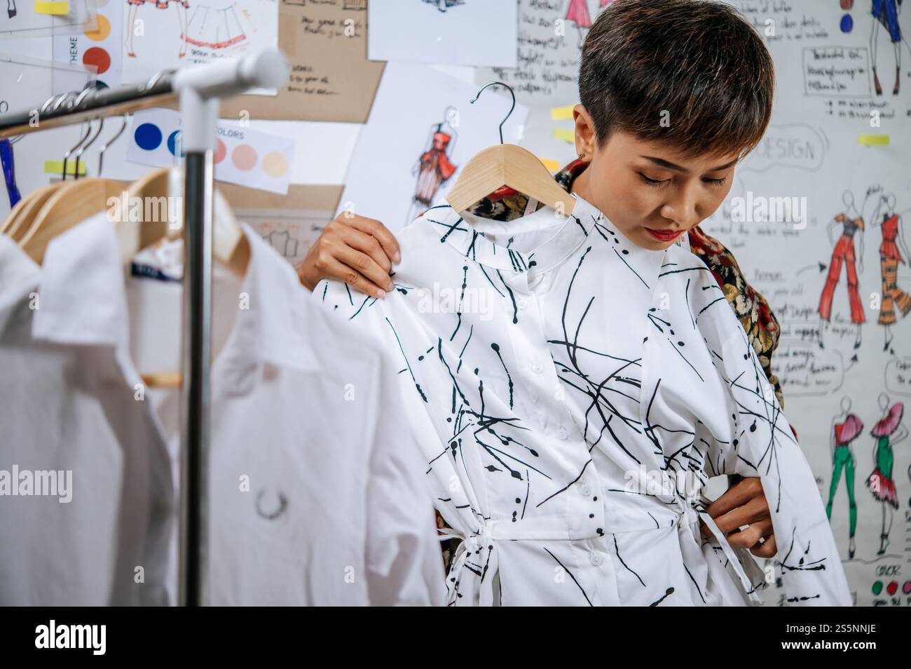 Young designer female put a nice shirt over her body with proud ...