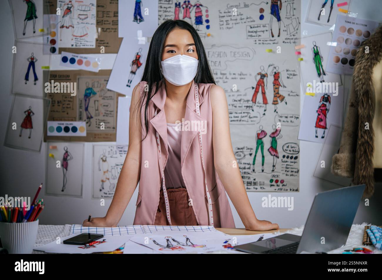 Portrait young asian female standing in modern atelier. Positive woman creative worker wearing ...