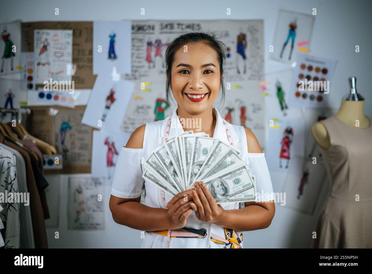 Portrait young asian designer or tailor female standing with a lot of ...