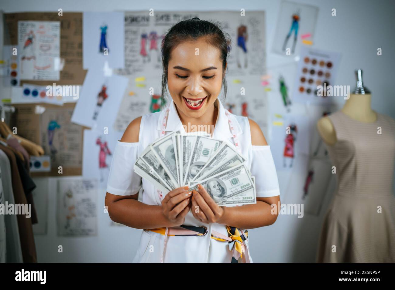 Portrait young asian designer or tailor female standing with a lot of ...