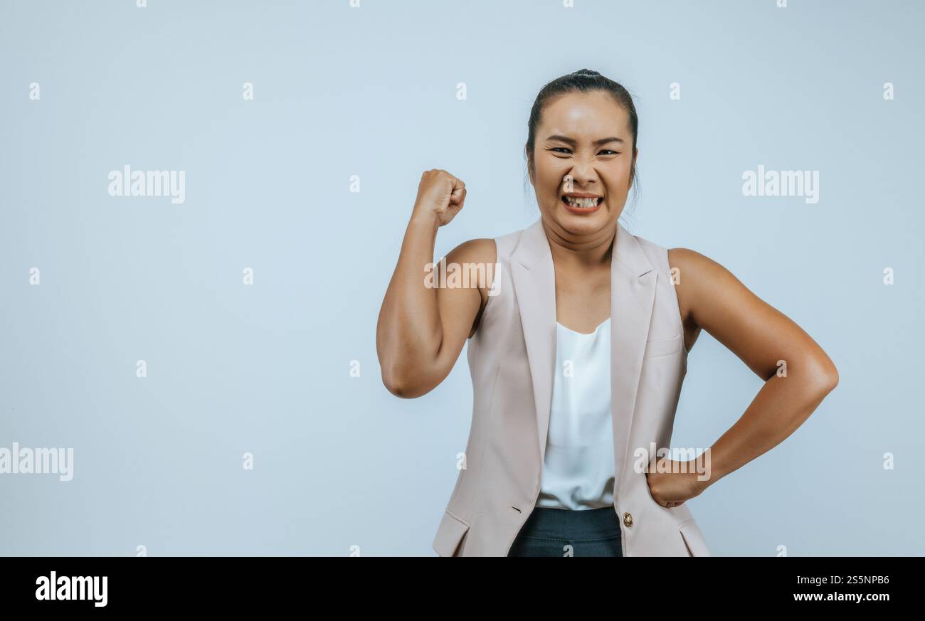 Portrait of emotive worried Asian woman showing clenched fist while ...