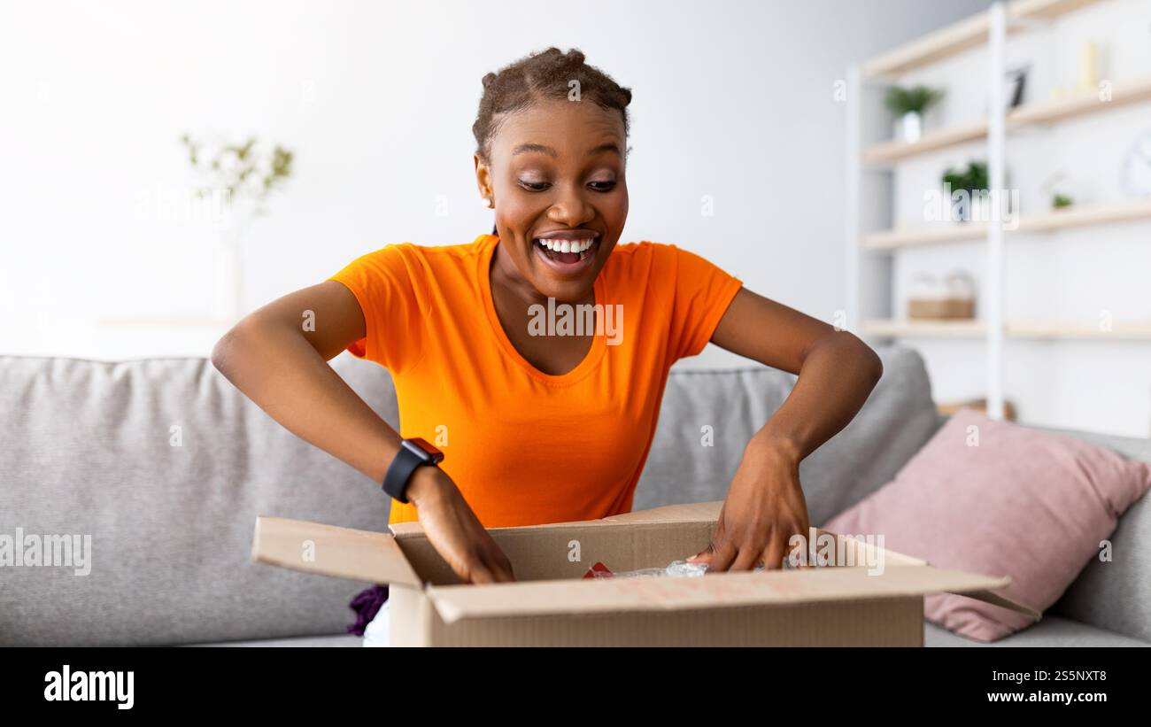 Emotional black female customer receiving long-awaited package, opening ...