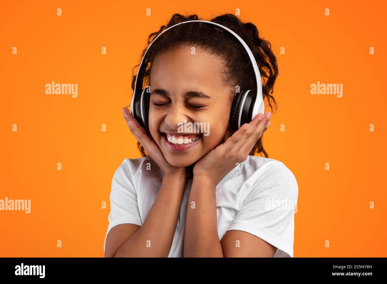 Smiling Young Black Girl Listening To Music In Headphones Stock Photo ...