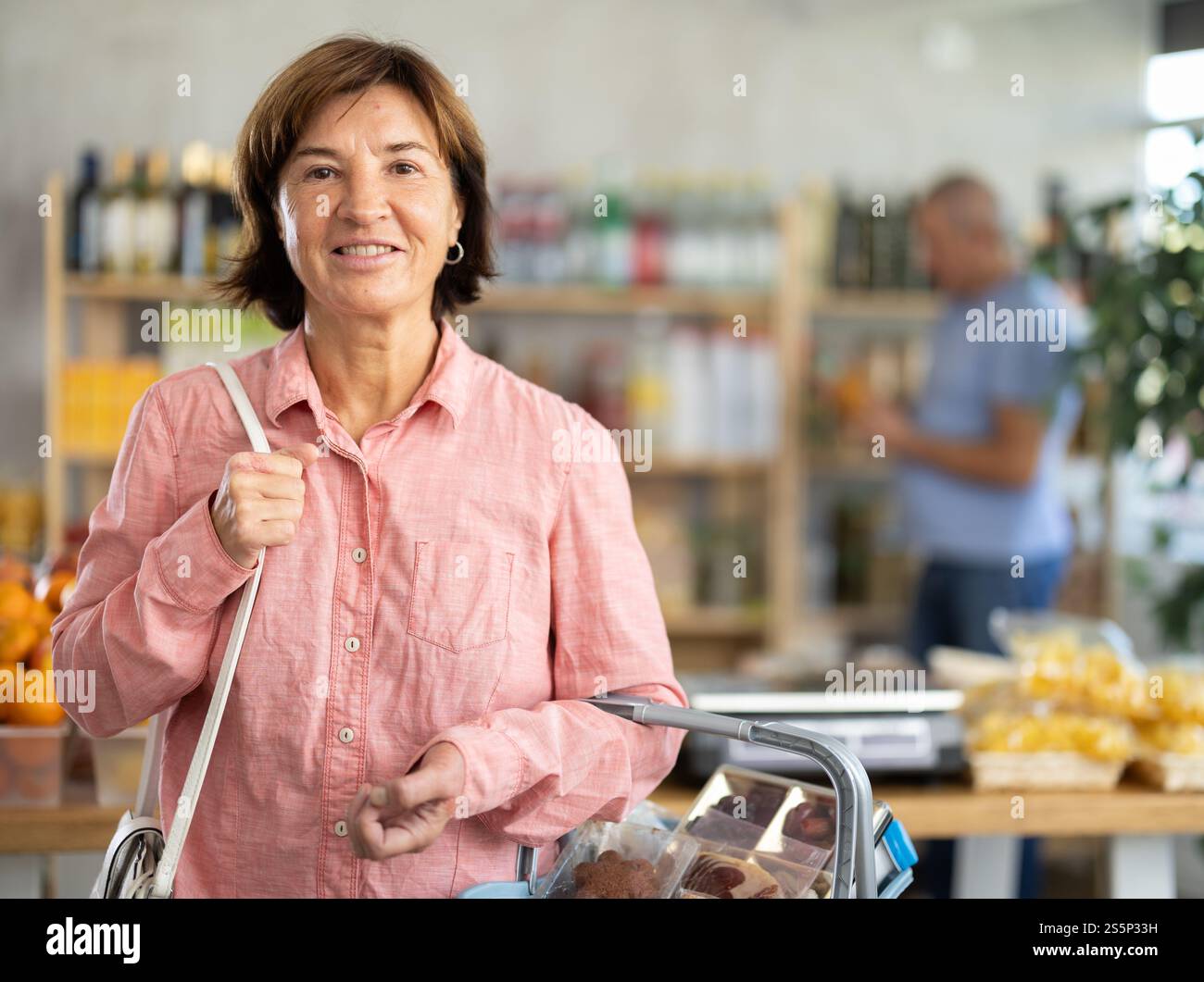 Visiting store, elderly woman is looking at something on shelf of ...