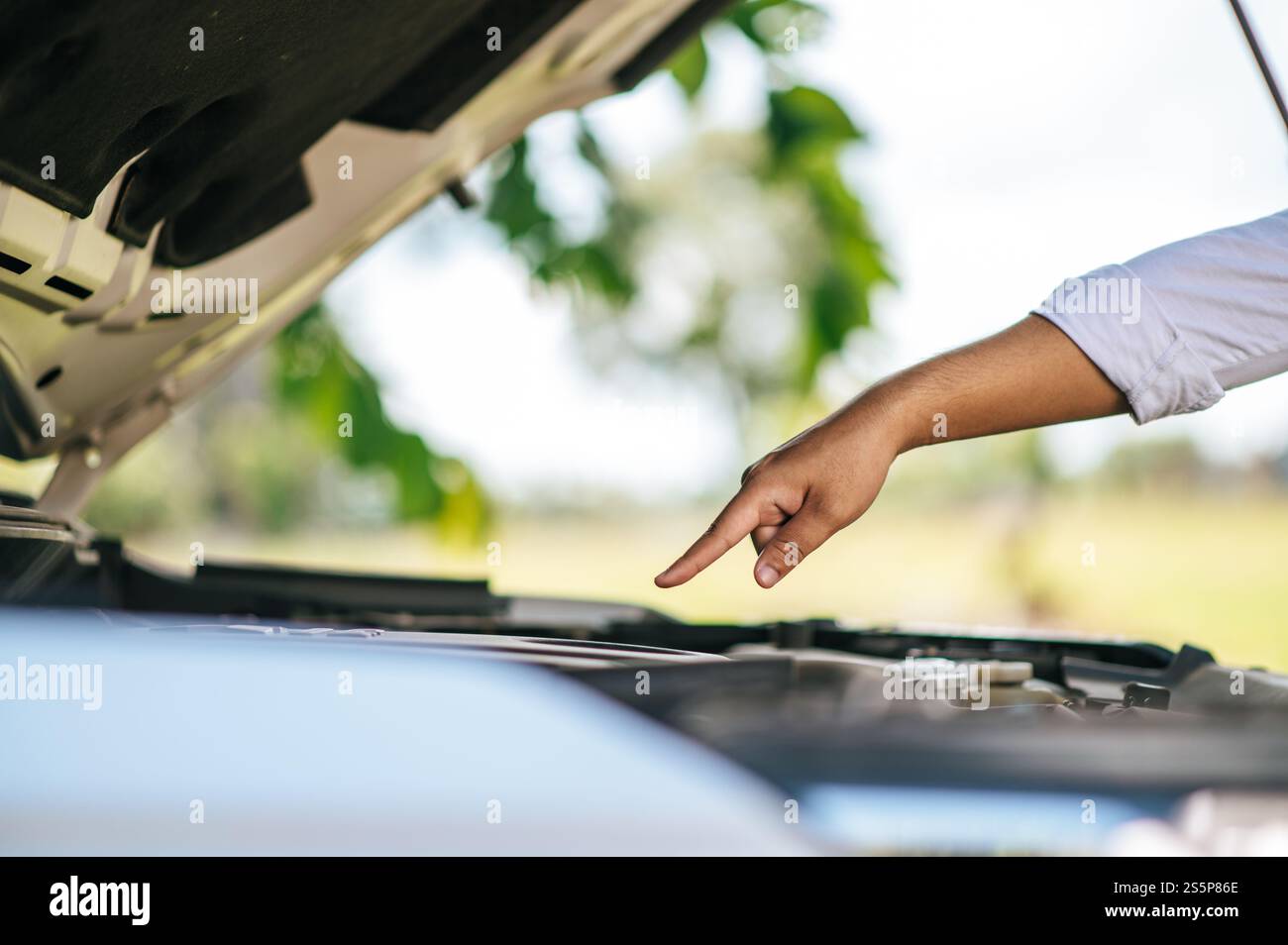 A man opens the hood of a car to repair the car due to a breakdown ...