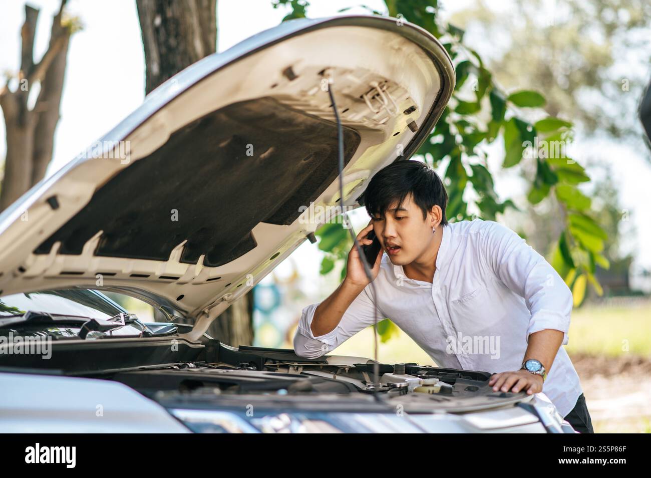 A man called a mechanic to fix the car because the car broke down Stock ...