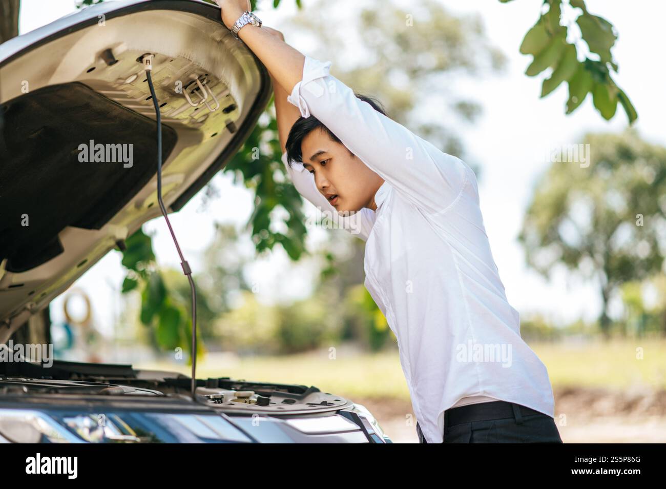 A man opens the hood of a car to repair the car due to a breakdown ...