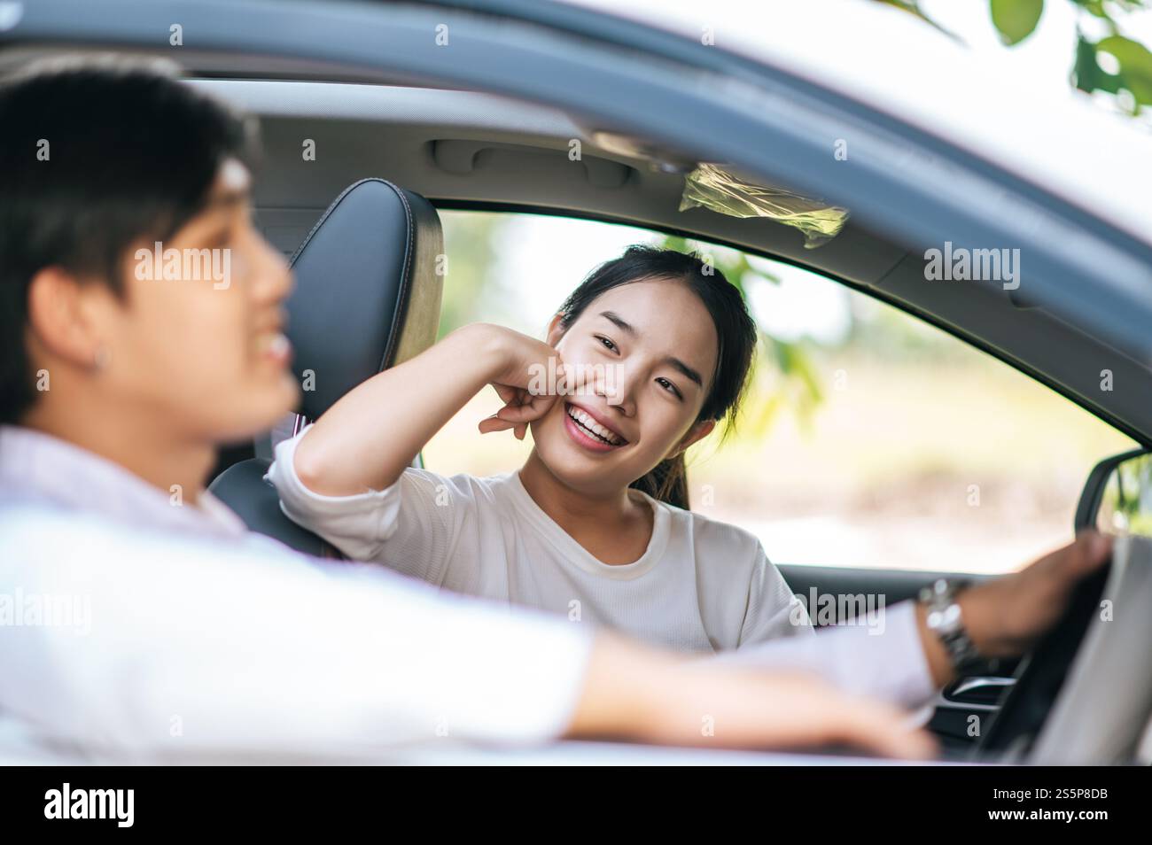 a woman and a man sitting in a car happily Stock Photo - Alamy