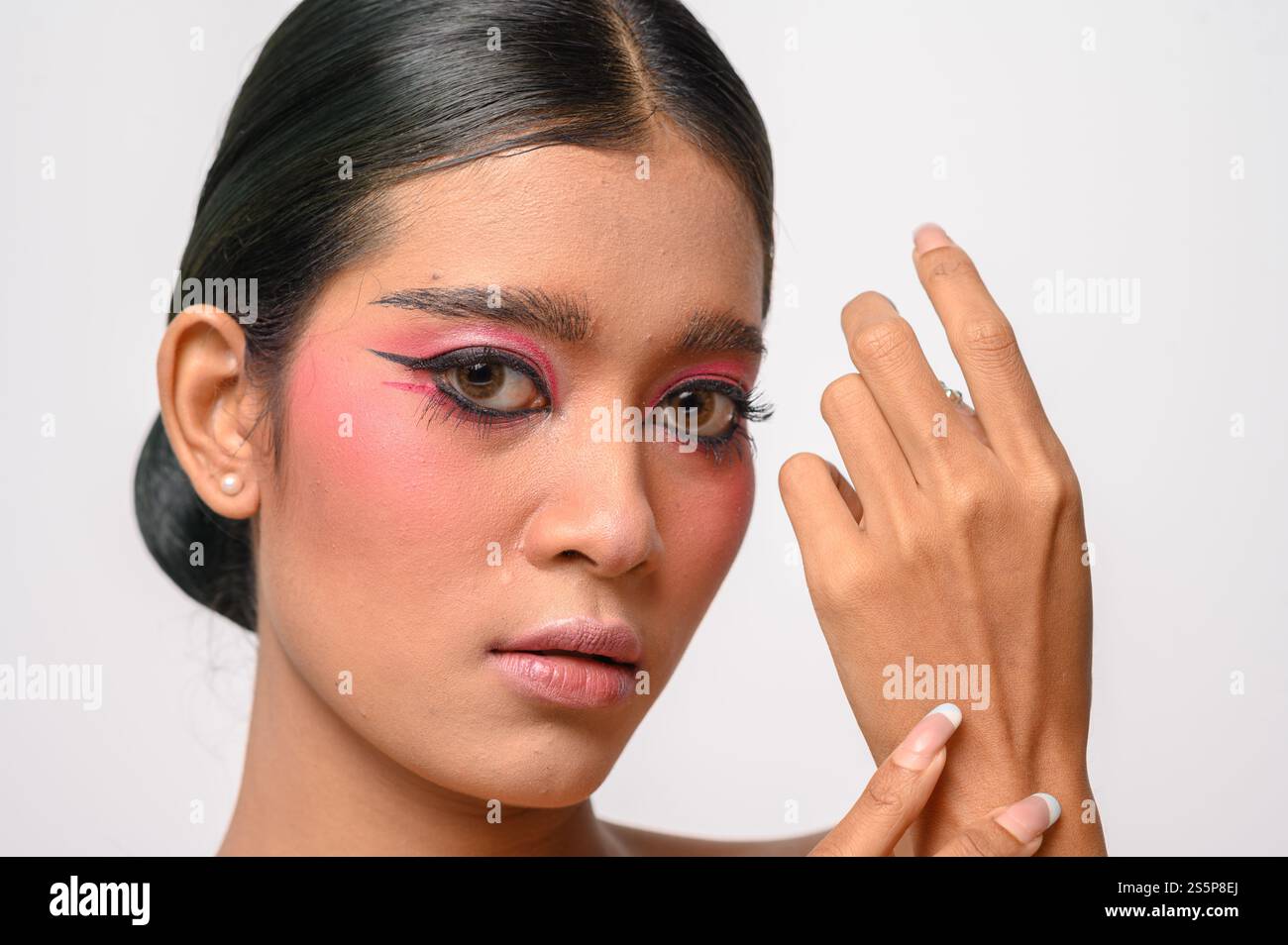 Pretty girl puts on pink makeup and puts her hand on the back of her ...