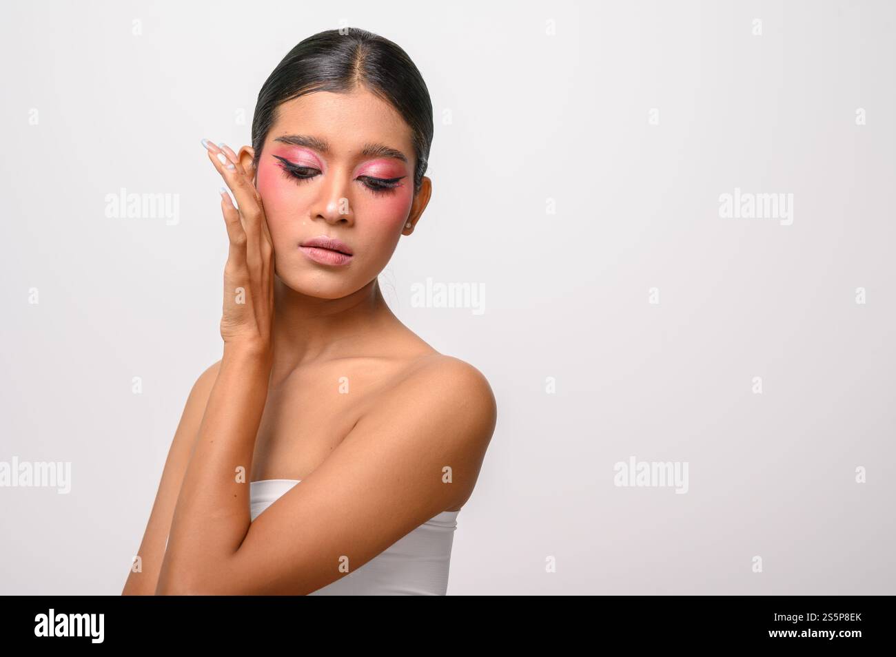 The woman put on pink makeup and put her hand on her face. Isolated on ...